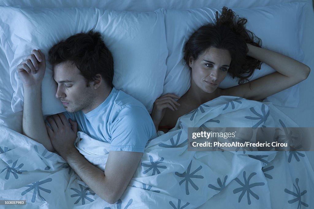 Couple Lying Together In Bed Woman Restlessly Awake Looking Away High