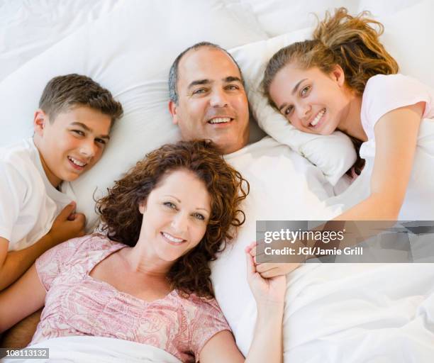 60 Overhead View Smiling Mother And Daughter Hugging On Bed Stock