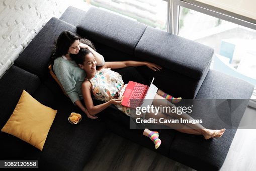 High Angle View Of Lesbian Couple Watching Video Over Laptop Computer
