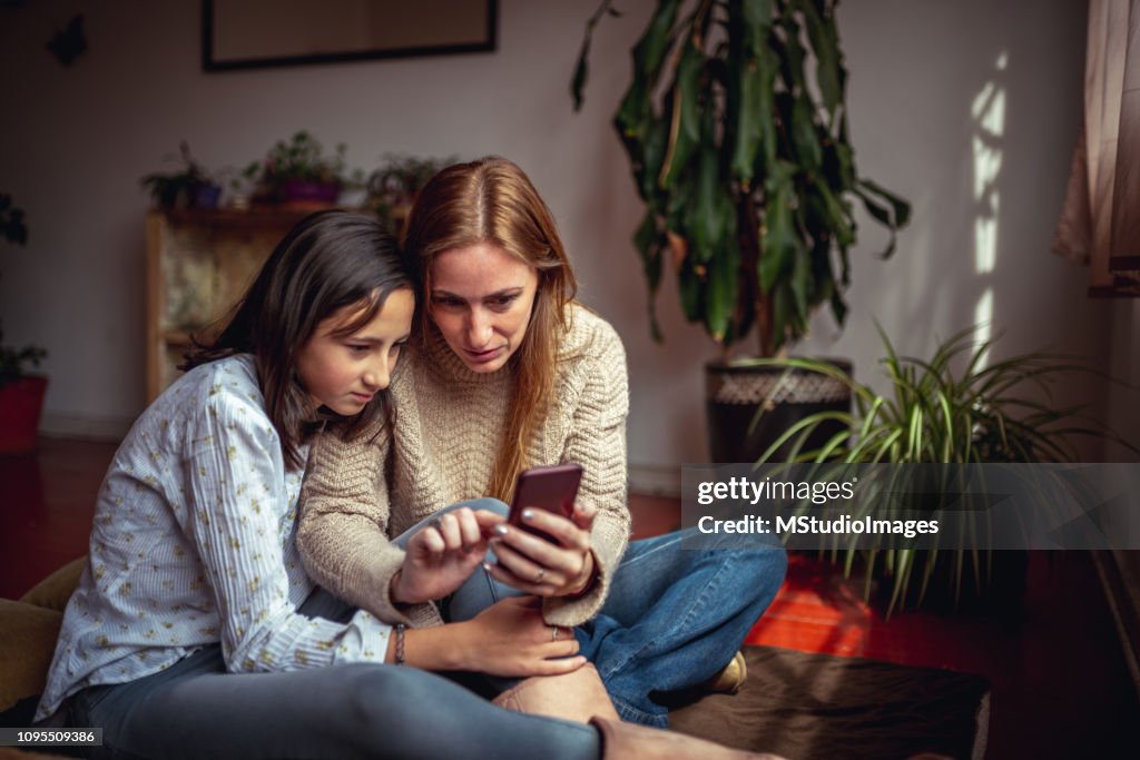 Mère Et Fille À Laide De Téléphone Portable Photo Getty Images