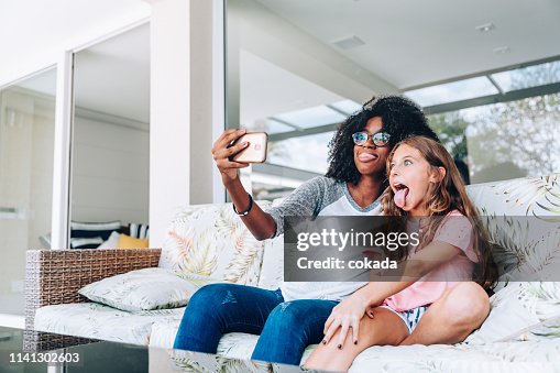 Two Young Friends Making Funny Faces While Taking A Selfie High Res