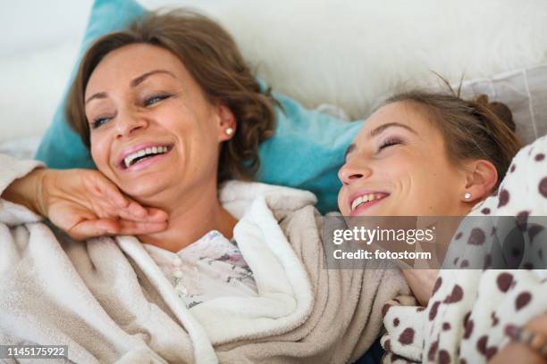 60 Overhead View Smiling Mother And Daughter Hugging On Bed Stock