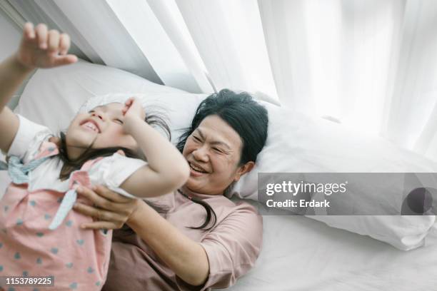 60 Overhead View Smiling Mother And Daughter Hugging On Bed Stock