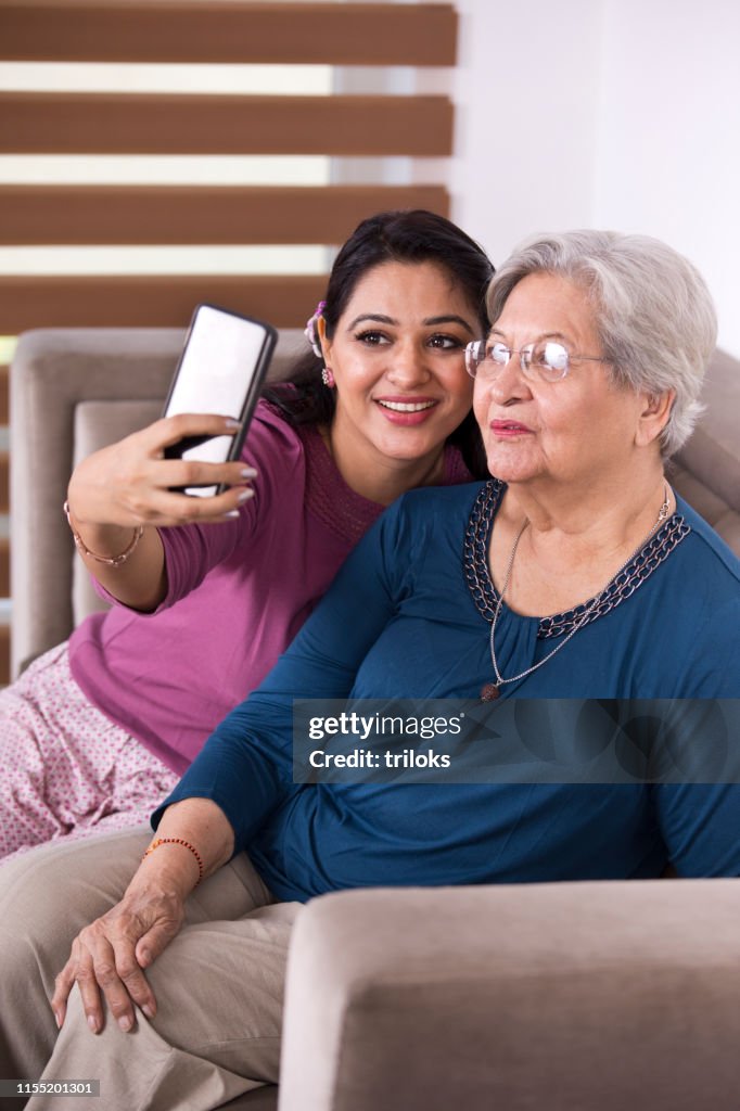 Woman With Senior Mother Using Mobile Phone For Video Chat High-Res ... Woman With Senior Mother Using Mobile Phone For Video Chat High-Res ...