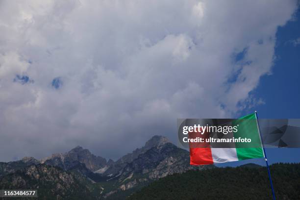 Italian flags fluttering in the wind. Summer landscape. Beautiful view ...
