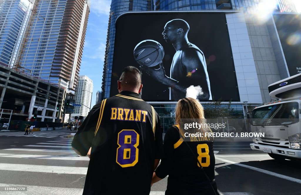 Fans dressed in their Kobe Bryant jerseys approach a billboard... News ... Fans dressed in their Kobe Bryant jerseys approach a billboard... News ...