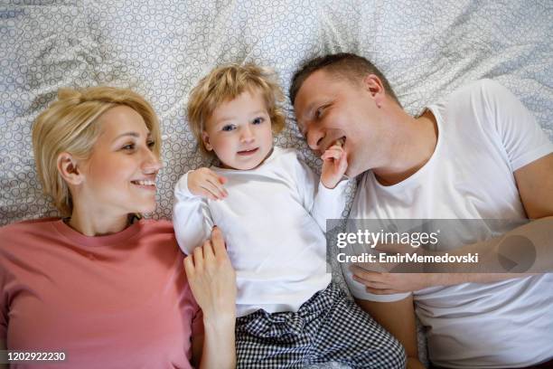 60 Overhead View Smiling Mother And Daughter Hugging On Bed Stock
