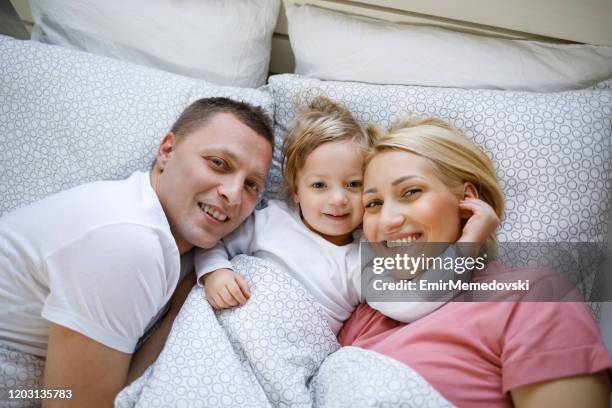 60 Overhead View Smiling Mother And Daughter Hugging On Bed Stock