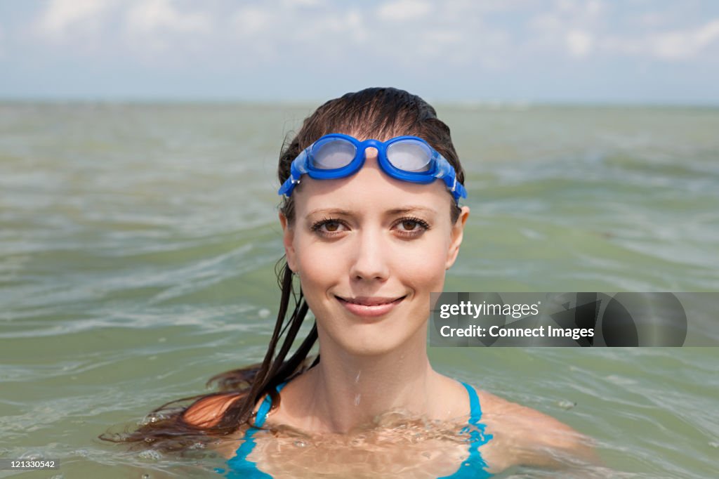 Young Woman Wearing Swimming Goggles In Sea Portrait High Res Stock