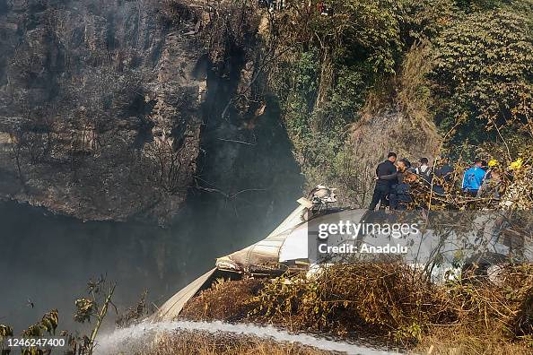 Rescuers gather at the site of a plane crash in Pokhara, Nepal on ... Rescuers gather at the site of a plane crash in Pokhara, Nepal on ...