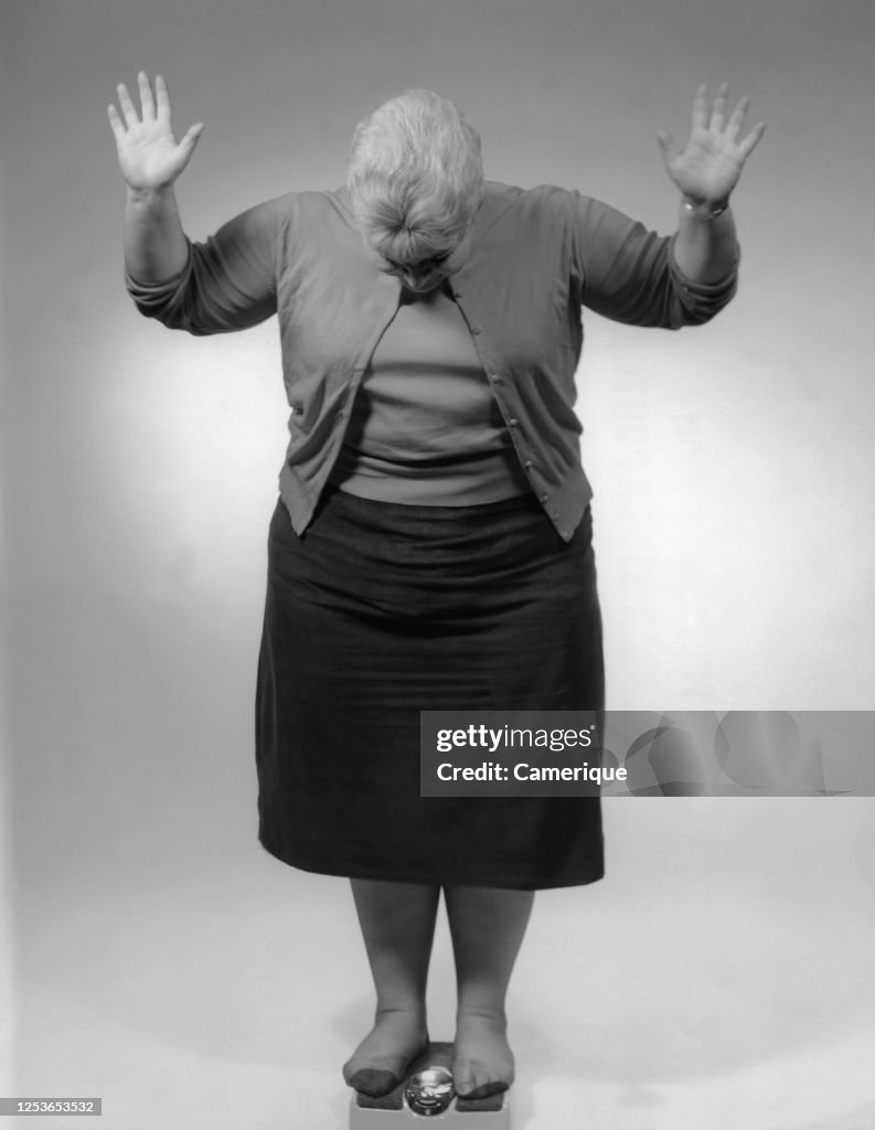 Overweight Woman Standing On A Scale With Her Hands Thrown Up News