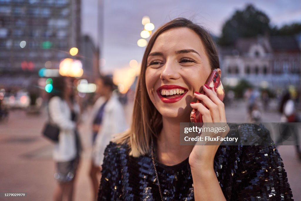 Cheerful Young Woman Laughing While Talking On A Mobile Phone Outdoors