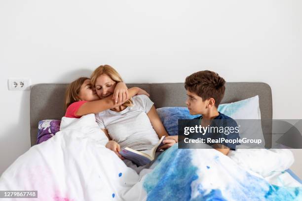60 Overhead View Smiling Mother And Daughter Hugging On Bed Stock
