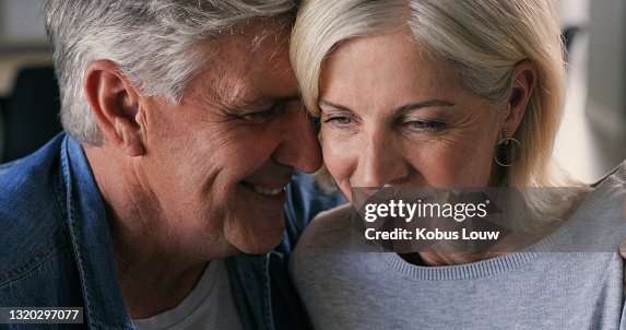 Shot Of A Mature Couple Sitting In Their Living Room Together And