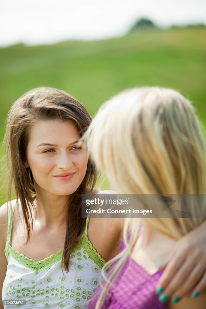 Young Lesbian Couple Looking At Each Other Intimately While Sitting In
