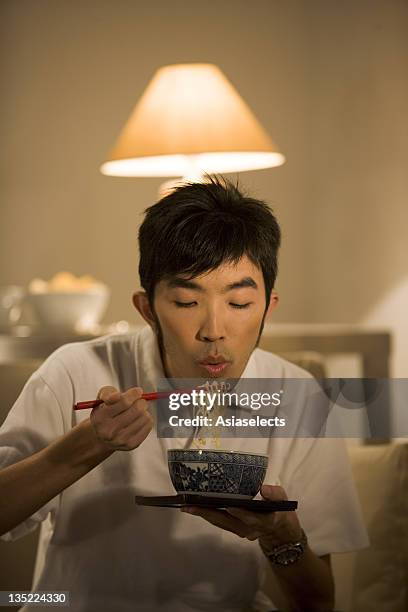 Young Man Eating Bowl Of Noodles Photos And Premium High Res Pictures