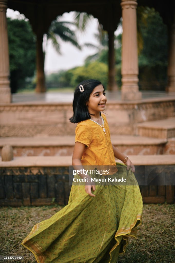 Indian Girl Wearing Traditional Clothes Spinning In Front Of An