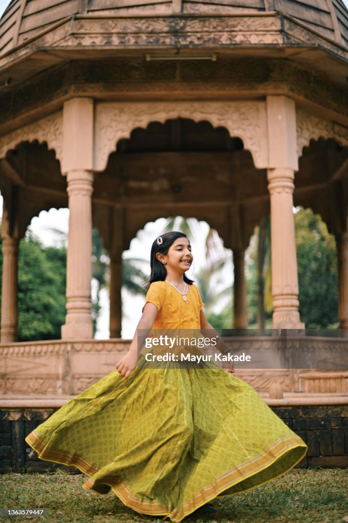 Indian Girl Wearing Traditional Clothes Spinning In Front Of An