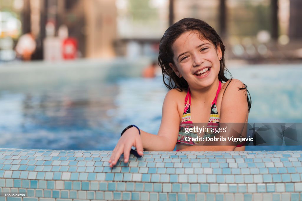 Young Girl Smiling And Enjoying Time At Swimming Pool High Res Stock