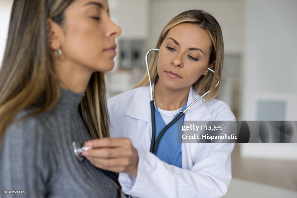 Doctor Performing A Medical Exam To A Patient At Home High Res Stock