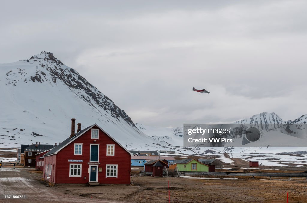 A plane flies above multicolored buildings and mountains at... News ... A plane flies above multicolored buildings and mountains at... News ...