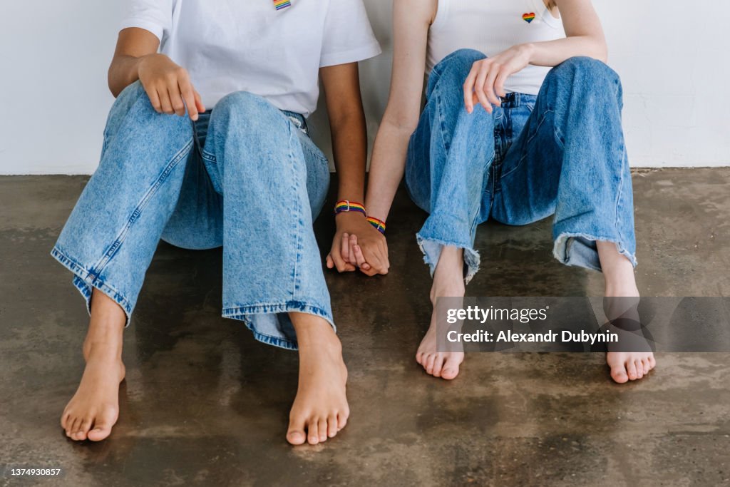 Two Women Multiethnic Lesbians Sit Together Holding Hands Lgbt