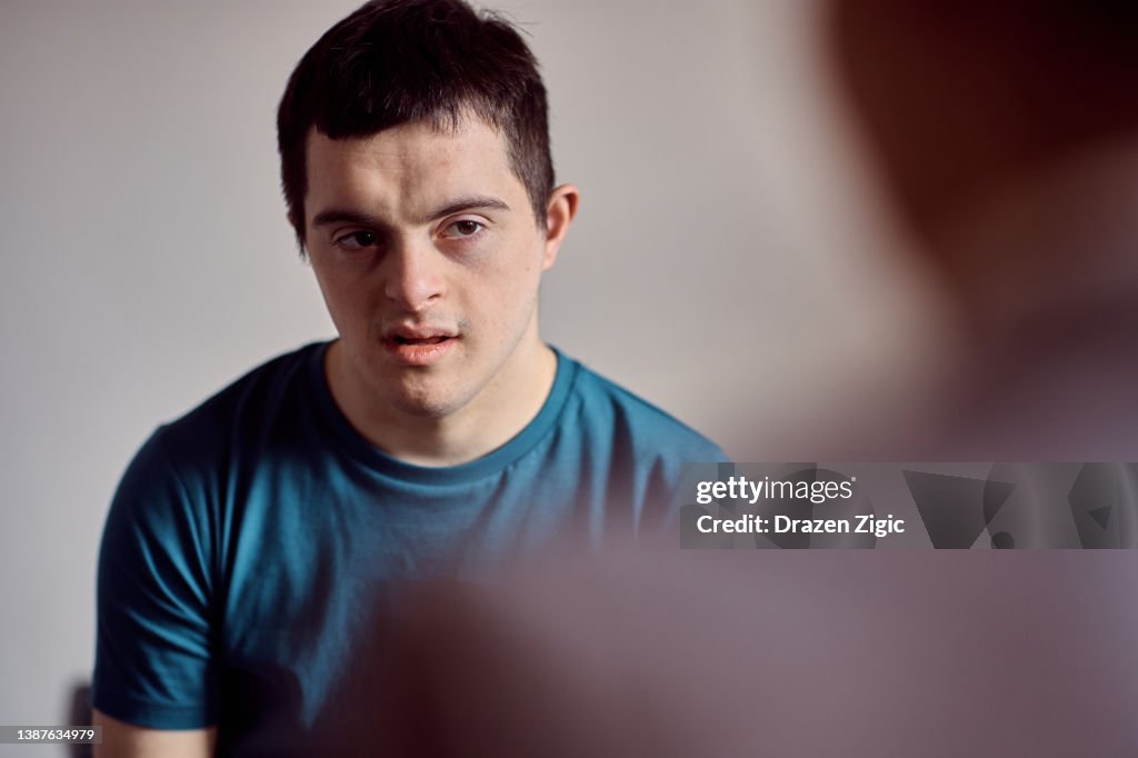 Young Down Syndrome Man Talking With His Therapist At Home High-Res ... Young Down Syndrome Man Talking With His Therapist At Home High-Res ...