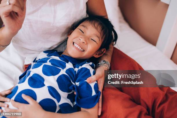 60 Overhead View Smiling Mother And Daughter Hugging On Bed Stock