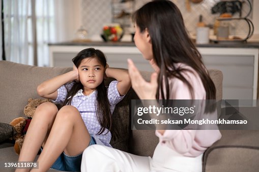 Angry Mother Shouting At Daughter Sitting On Couch At Home High Res