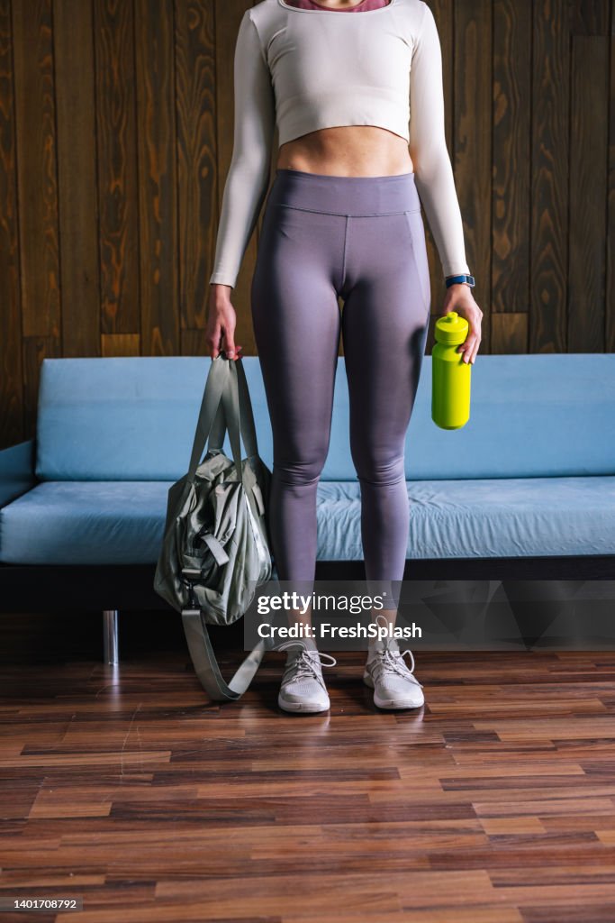 An Unrecognizable Muscular Sportswoman Standing In Front Of The Blue