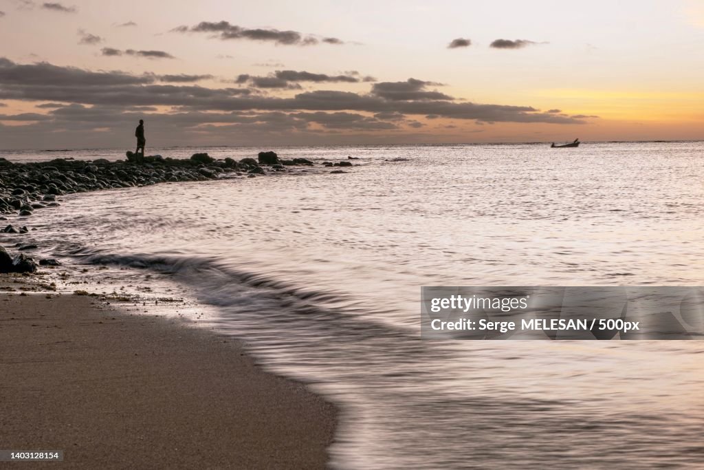 Silhouette Of Person Standing Against Scenic View Of Beach Against Sky