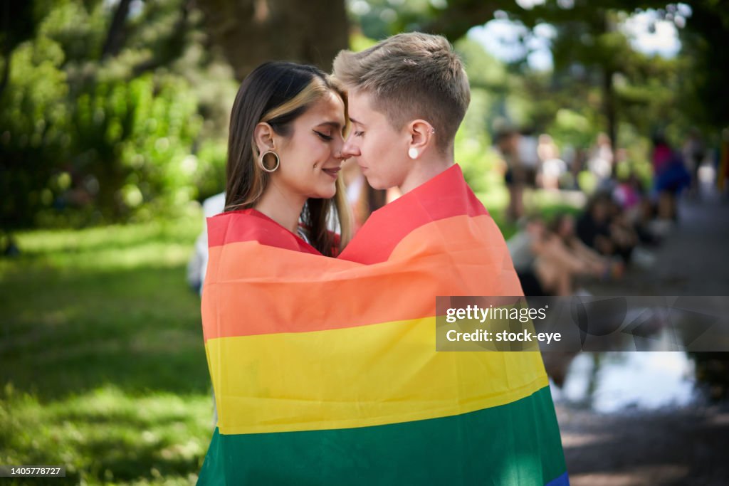 Lesbian Couple Embracing Each Other With Lgbt Pride Rainbow Flag High