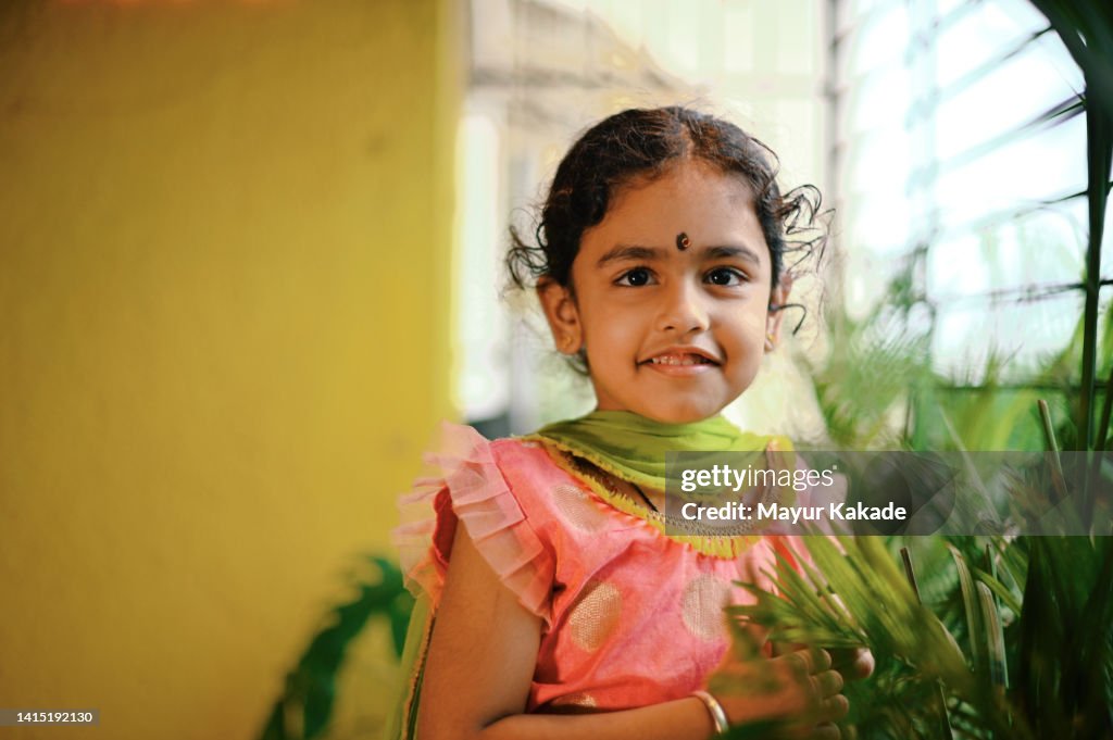 A Cute Indian Girl Wearing Traditional Clothes Standing In The Balcony