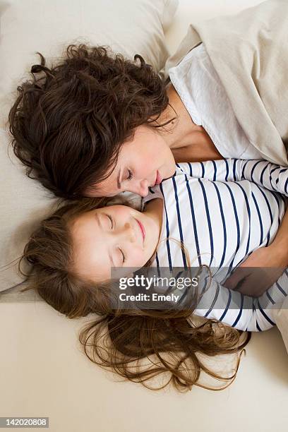 60 Overhead View Smiling Mother And Daughter Hugging On Bed Stock