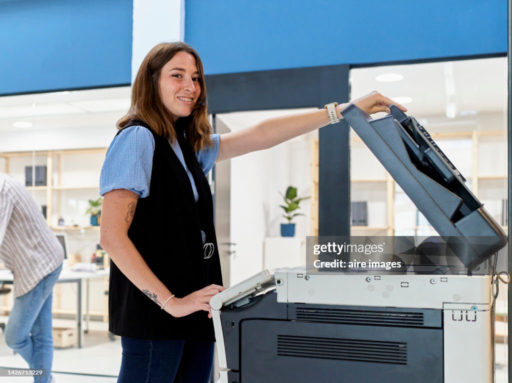 Woman Working In Modern Office Making Copies On Copier Machine Smiling ... Woman Working In Modern Office Making Copies On Copier Machine Smiling ...