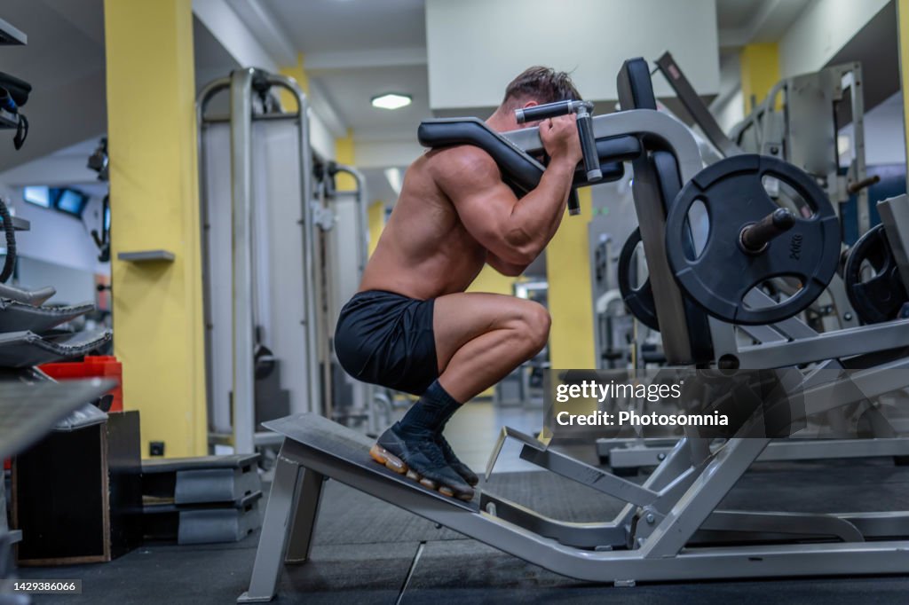 Man Doing Quadriceps Exercise On Hack Squat Machine At Gym High-Res ... Man Doing Quadriceps Exercise On Hack Squat Machine At Gym High-Res ...