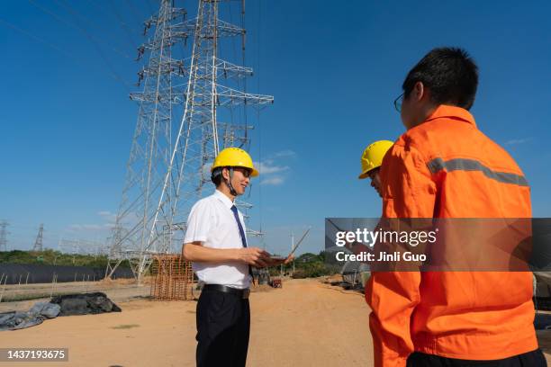 Power engineer holding laptop and discussing with workers 이미지 ...