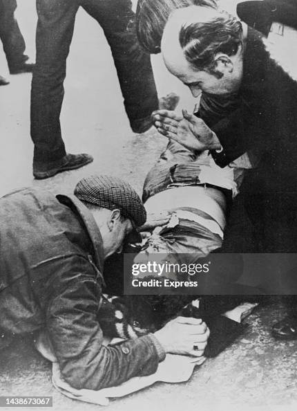 An Priest Administers The Last Rites To An Dying Rioter During The