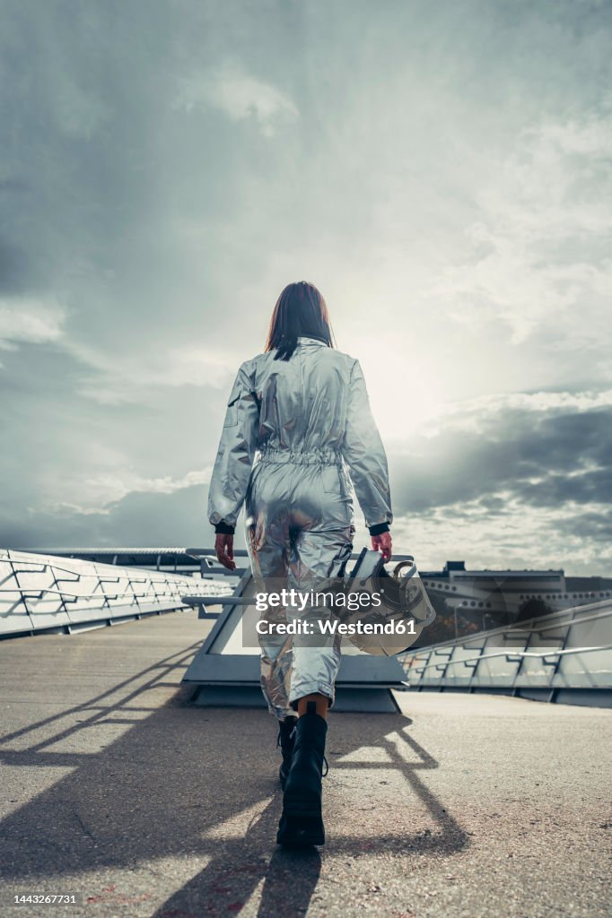 Astronaut Wearing Space Suit Holding Helmet Walking On Footpath High ... Astronaut Wearing Space Suit Holding Helmet Walking On Footpath High ...