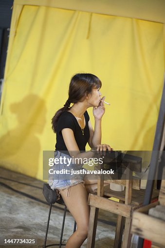 Vue De Profil Dune Jeune Femme Thaïlandaise Assise Et Fumant Dans Un