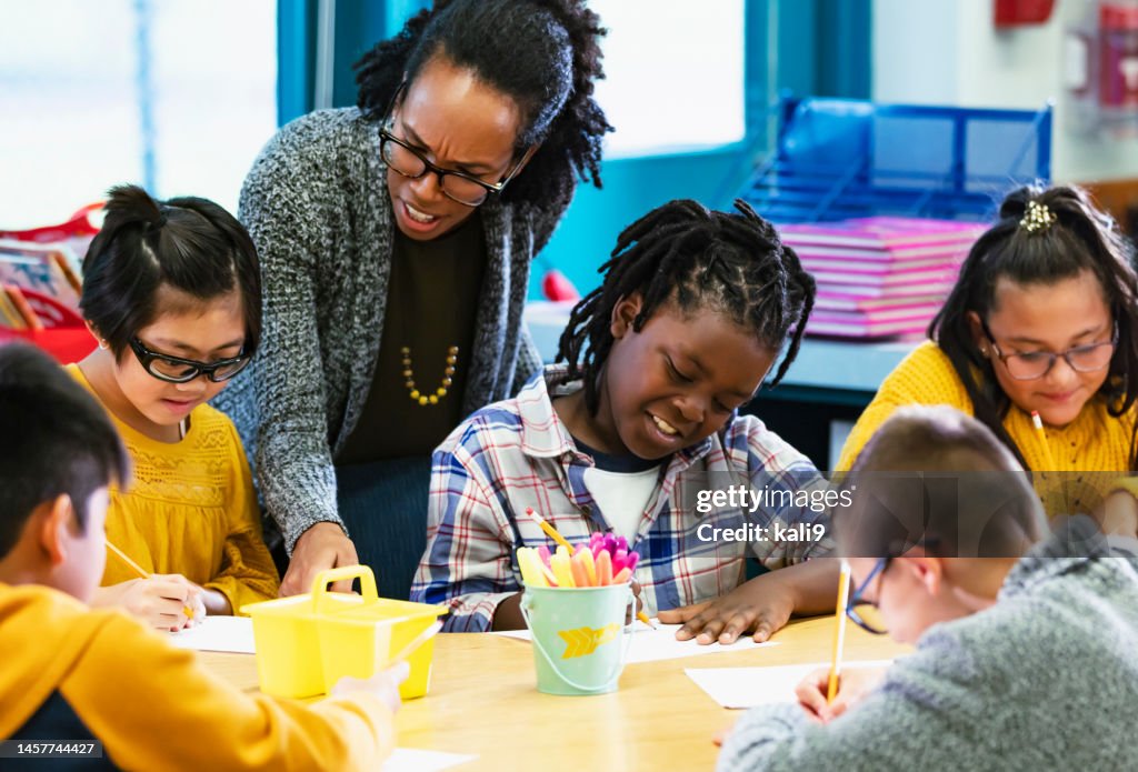 Teacher Helping Elementary Students Writing In Class High-Res Stock ... Teacher Helping Elementary Students Writing In Class High-Res Stock ...