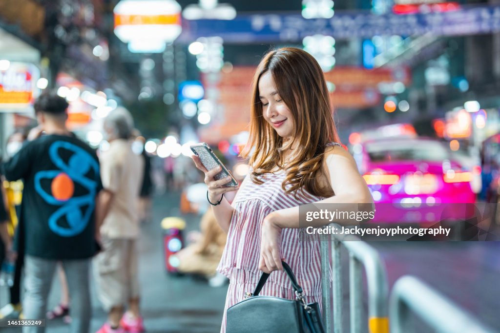 Young Asian Woman Using Smart Phone At Yaowarat Street Food In Bangkok Thailand High Res Stock