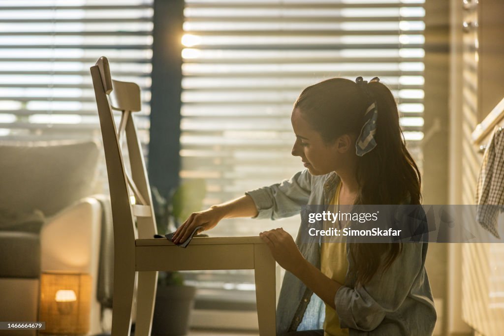 Young Woman Is Grinding Her Wooden Chair With Sandpaper Holding The