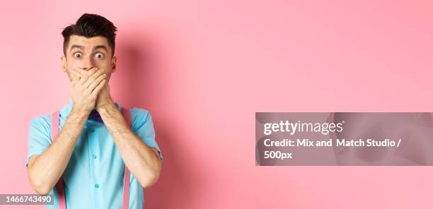 Portrait Of Young Man Covering His Mouth With Hand Photos And Premium