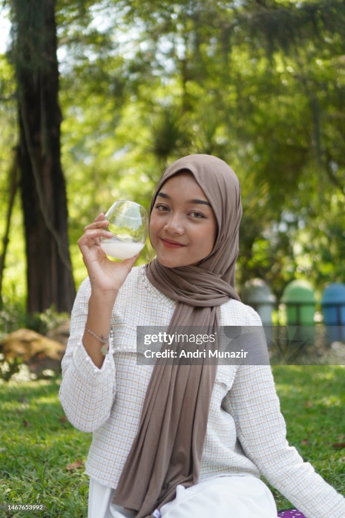 Portrait Of A Beautiful Woman In Hijab Drinking Milk High Res Stock