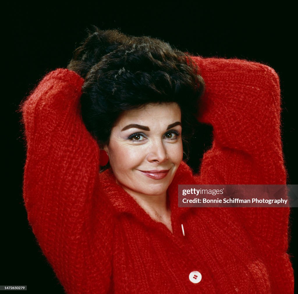 Actress Annette Funicello Poses With Her Hands On Her Head In A Red