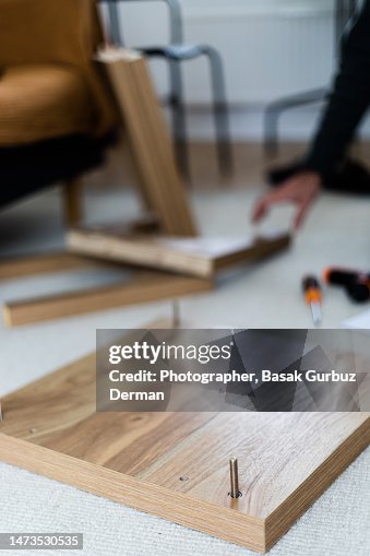 A Man Assembling Wooden Furniture Installing Screws And Nutsbolts ストック