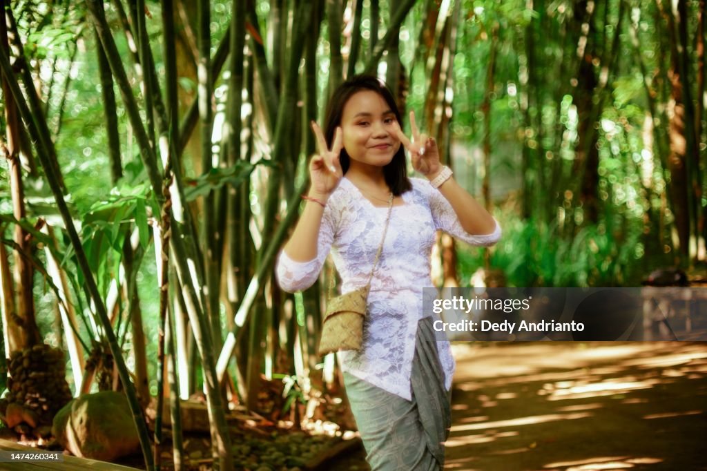 Asian Girl Wearing White Traditional Kebaya And Batik Sarong Showing
