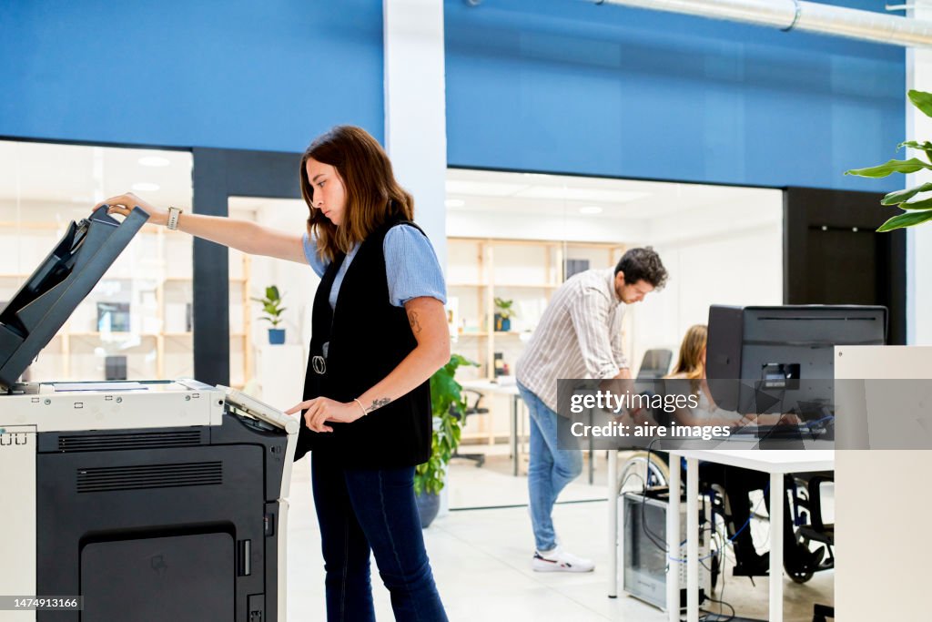 Woman Working In Modern Office Making Copies On Copier Machine Smiling ... Woman Working In Modern Office Making Copies On Copier Machine Smiling ...