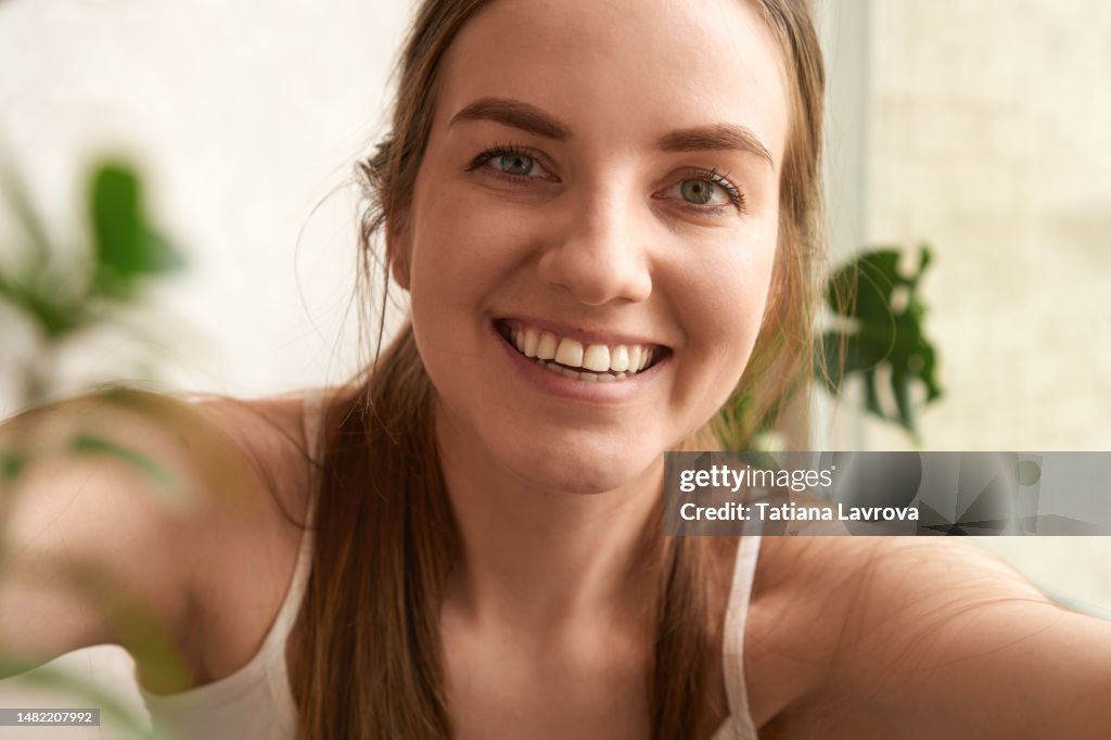 Portrait Of A Young Woman Taking Selfies Using Her Camera At Home